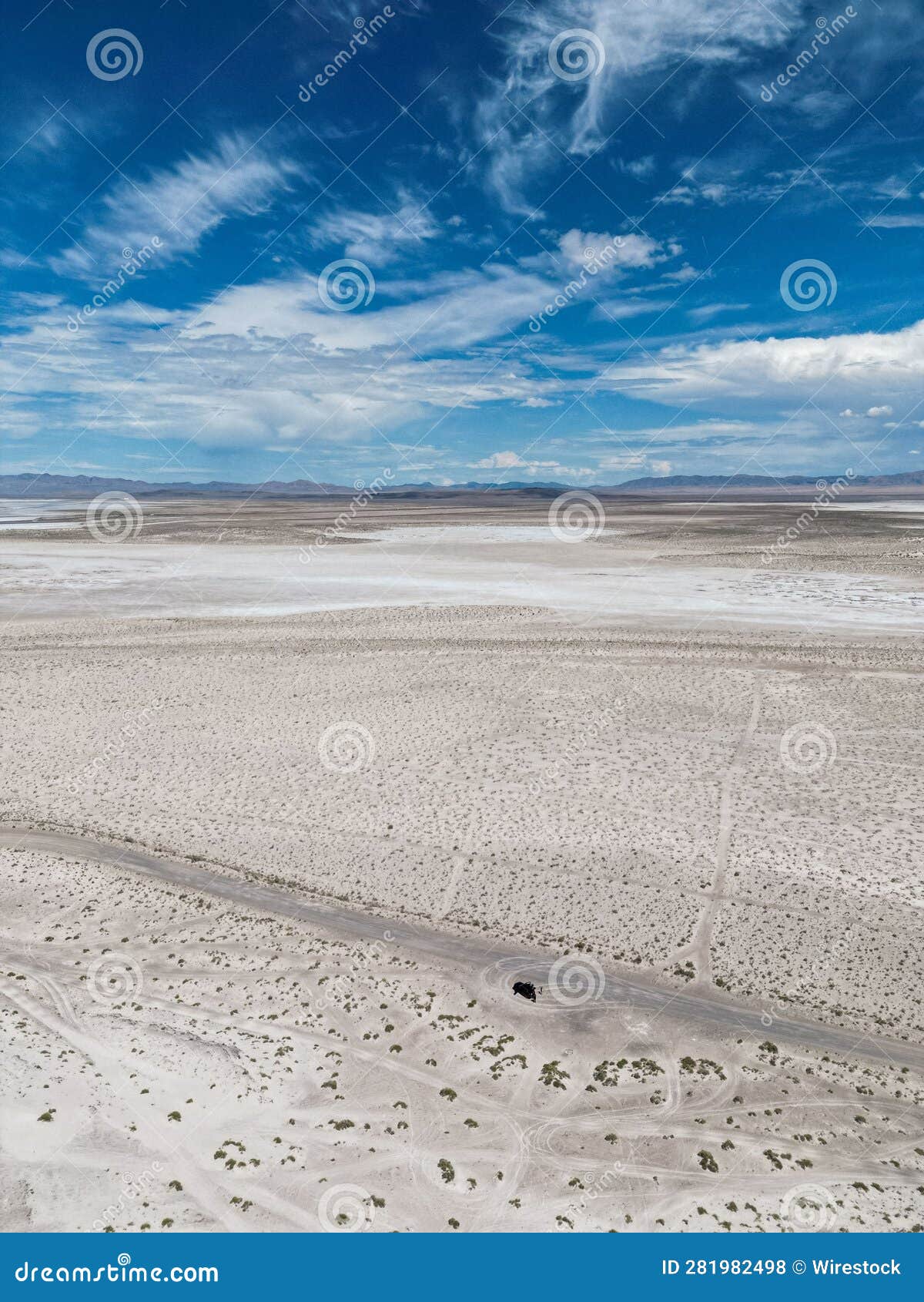 A White Sandy Plain Surrounded by Mountains and Plains Under a Cloudy ...