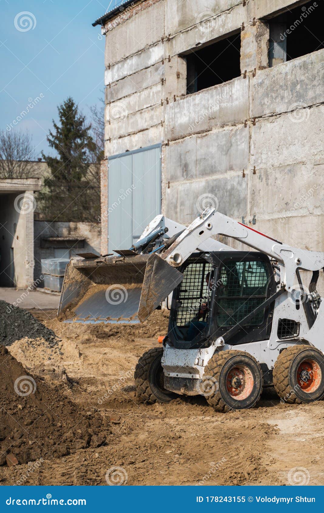 White Skid Steer Loader at a Construction Site Working with a Soil ...