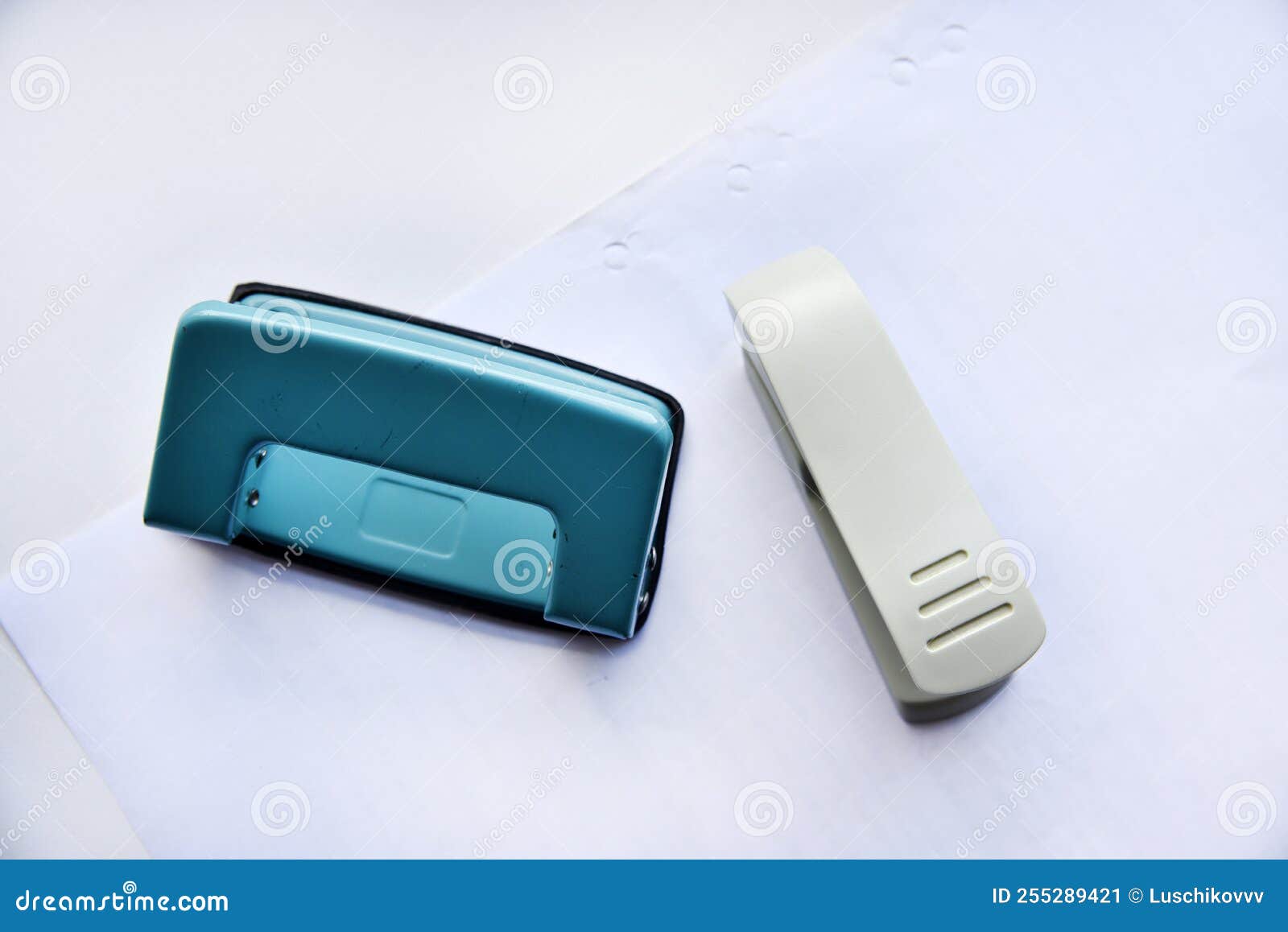 A White Stapler and a Green Hole Punch on a White Background ...