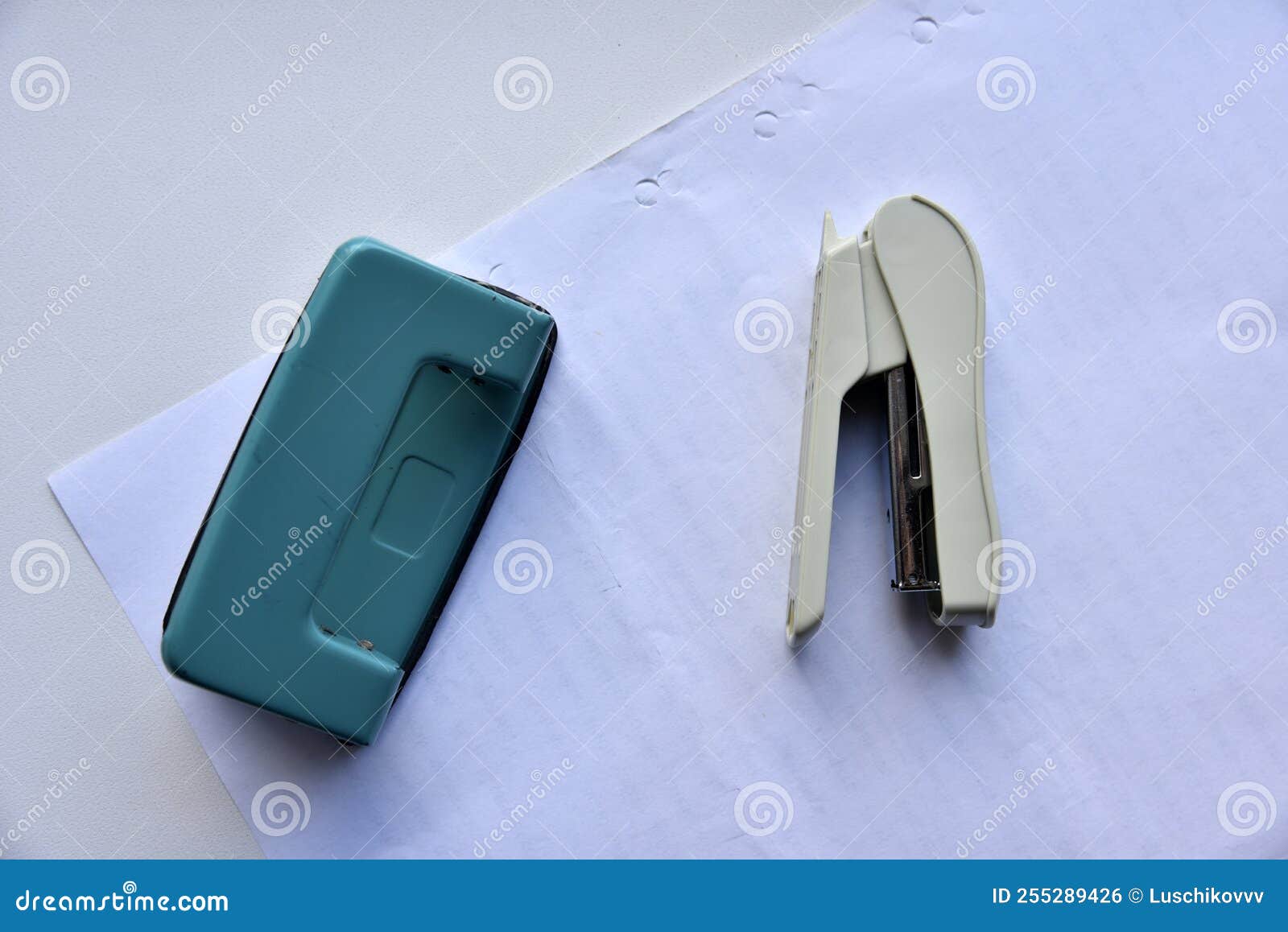 A White Stapler and a Green Hole Punch on a White Background ...