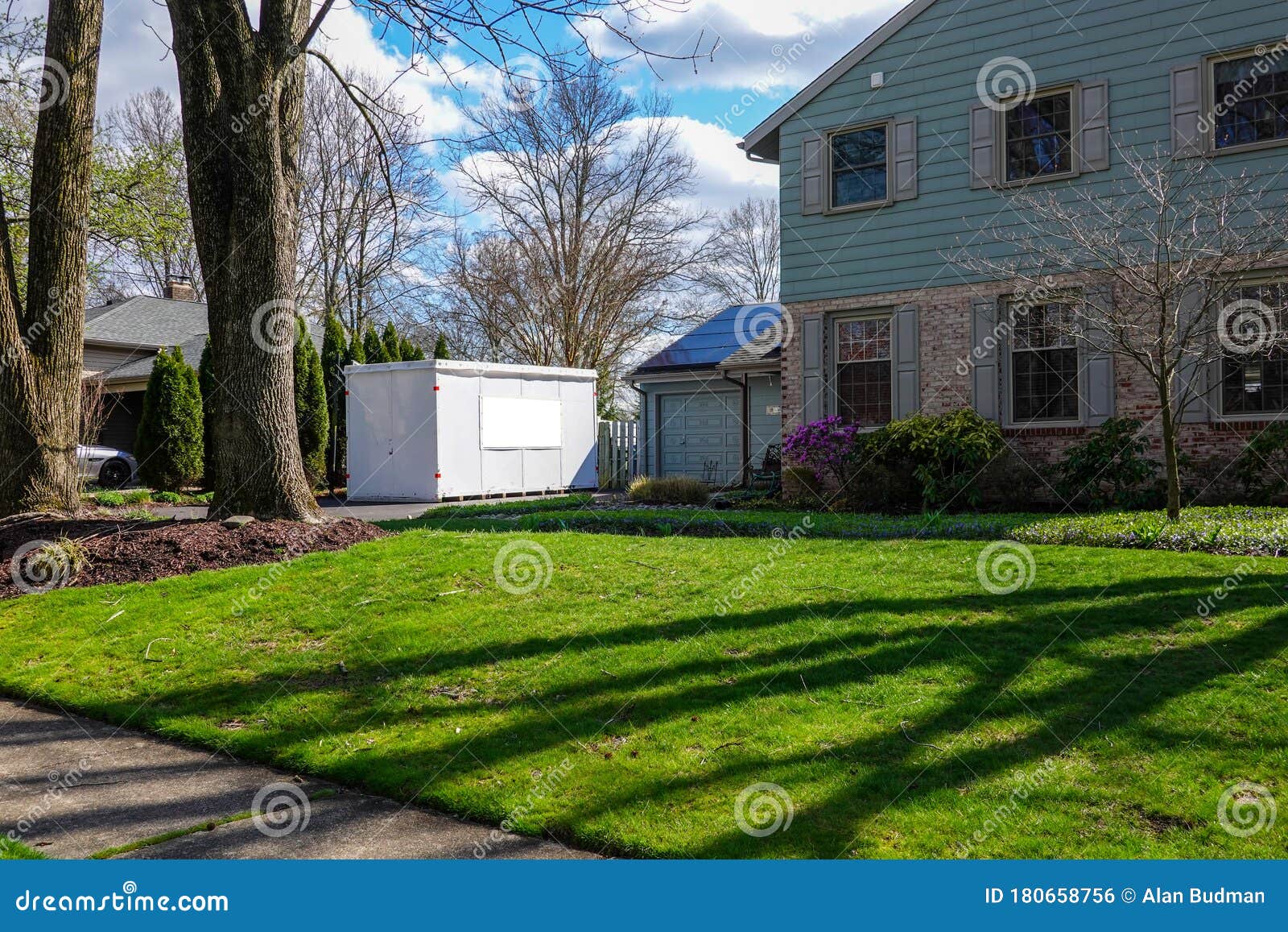 White Storage Pod Unit in the Driveway of a Home that Has Solar Panels ...
