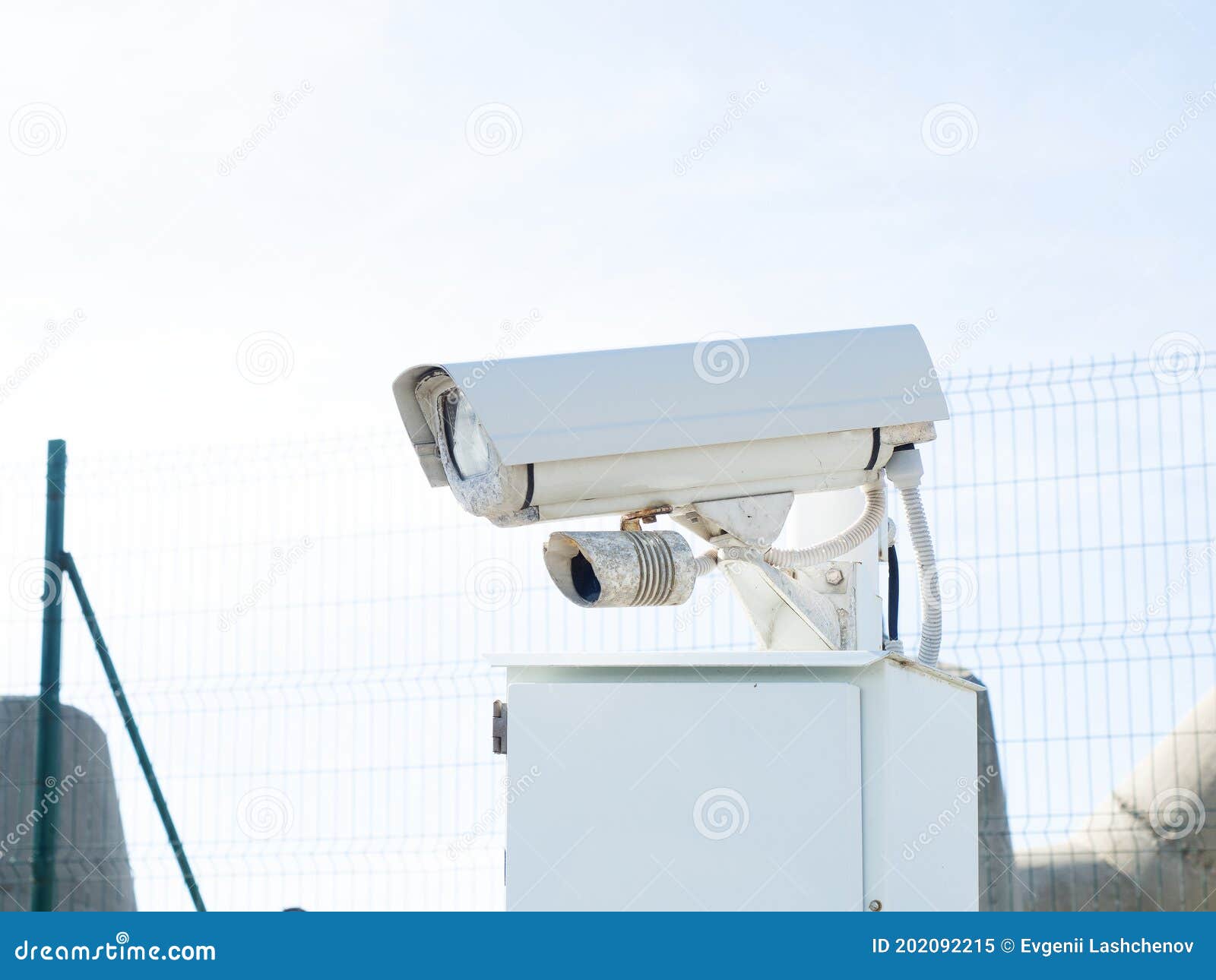 White Surveillance Camera on a Stand Outdoors Behind a Fence Stock ...