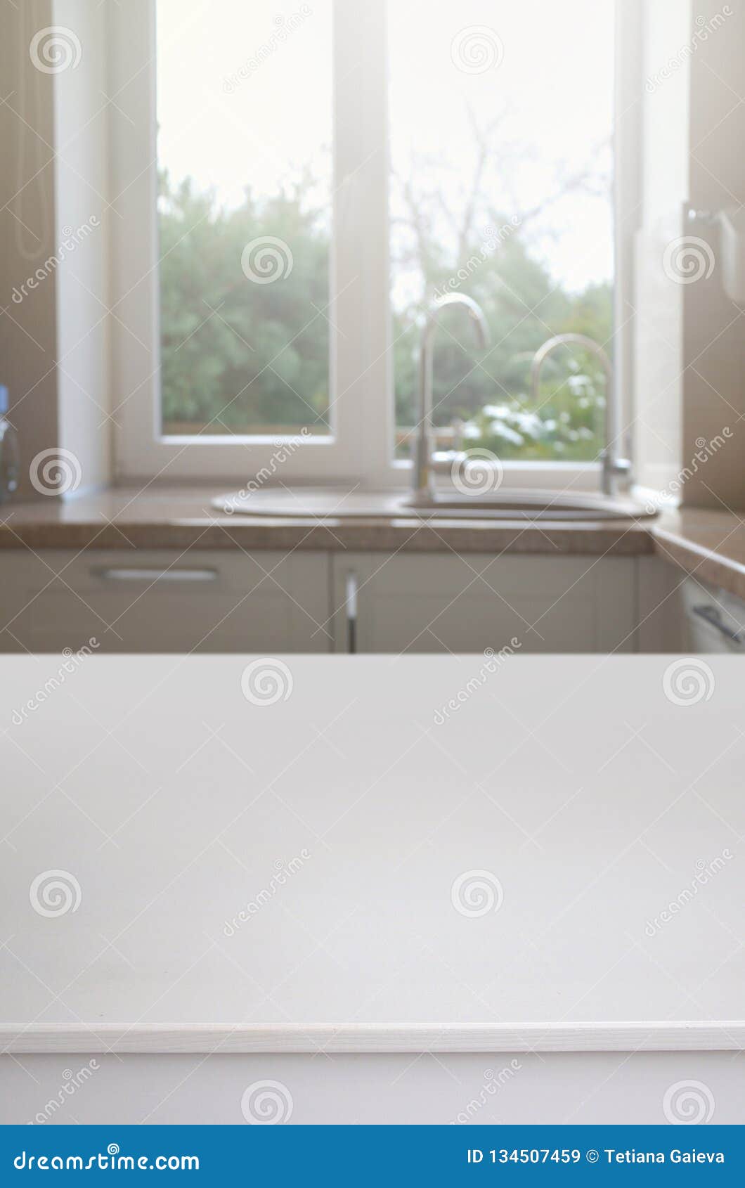 White Table Against a Blurred Window in the Interior of the Kitchen ...