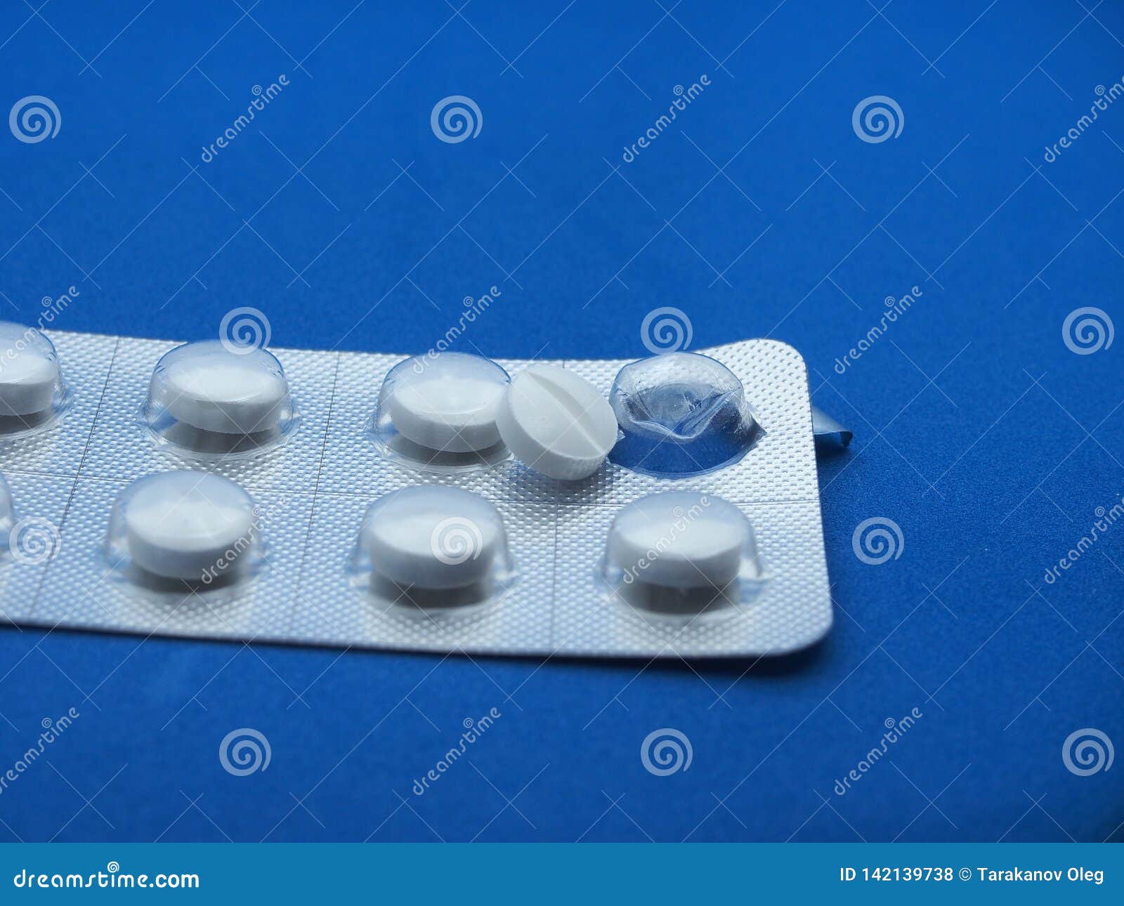 White Tablets on a Blue Background. One Tablet without Packaging, the ...