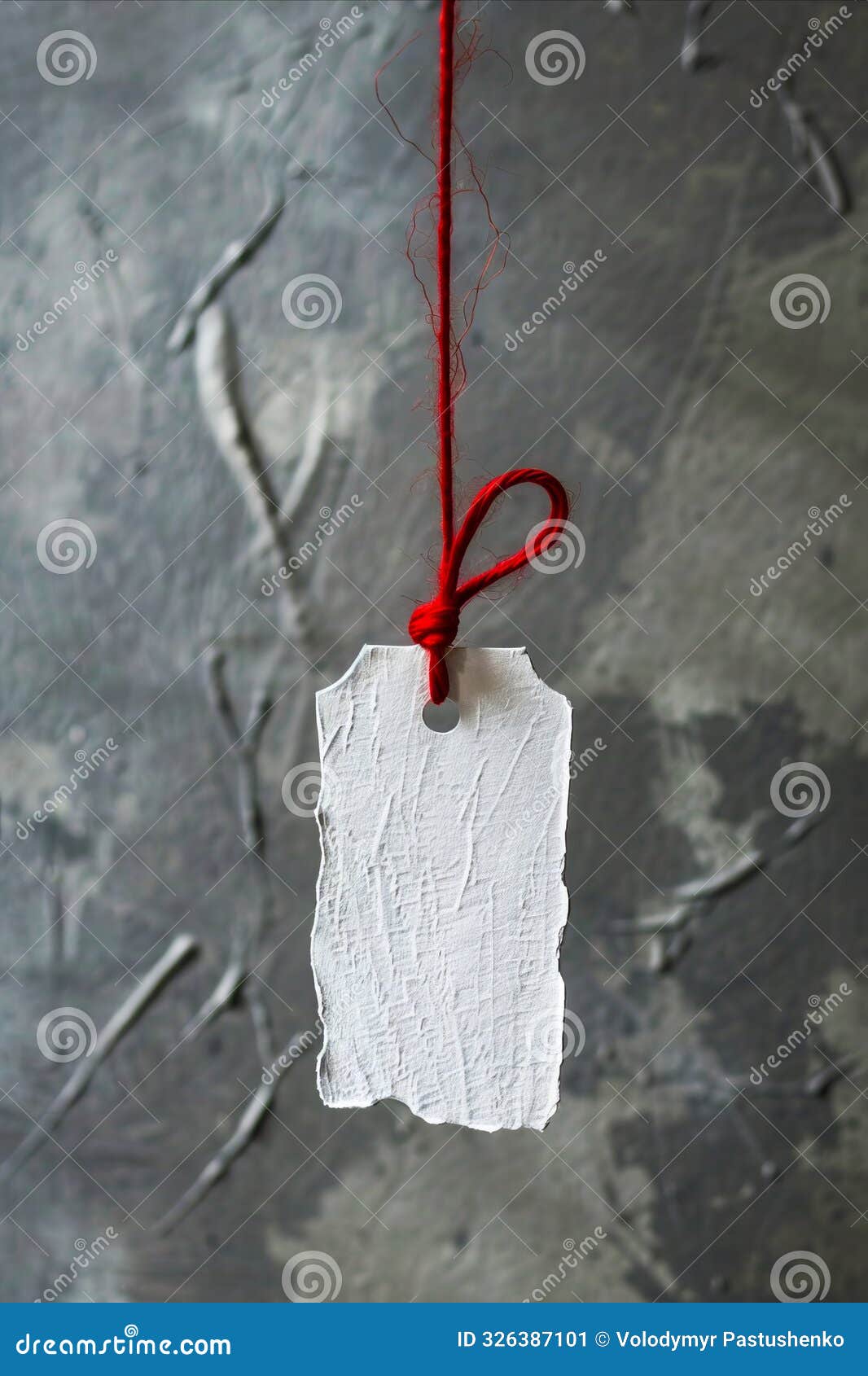 A White Tag Hanging from a String on a Concrete Wall Stock Image ...