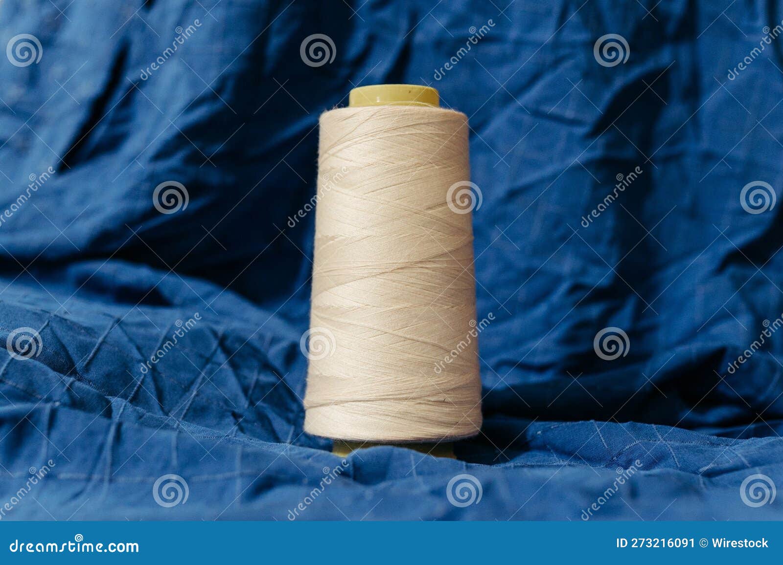 An Image of a White Thread Spool on a Blue Cloth Stock Image - Image of ...