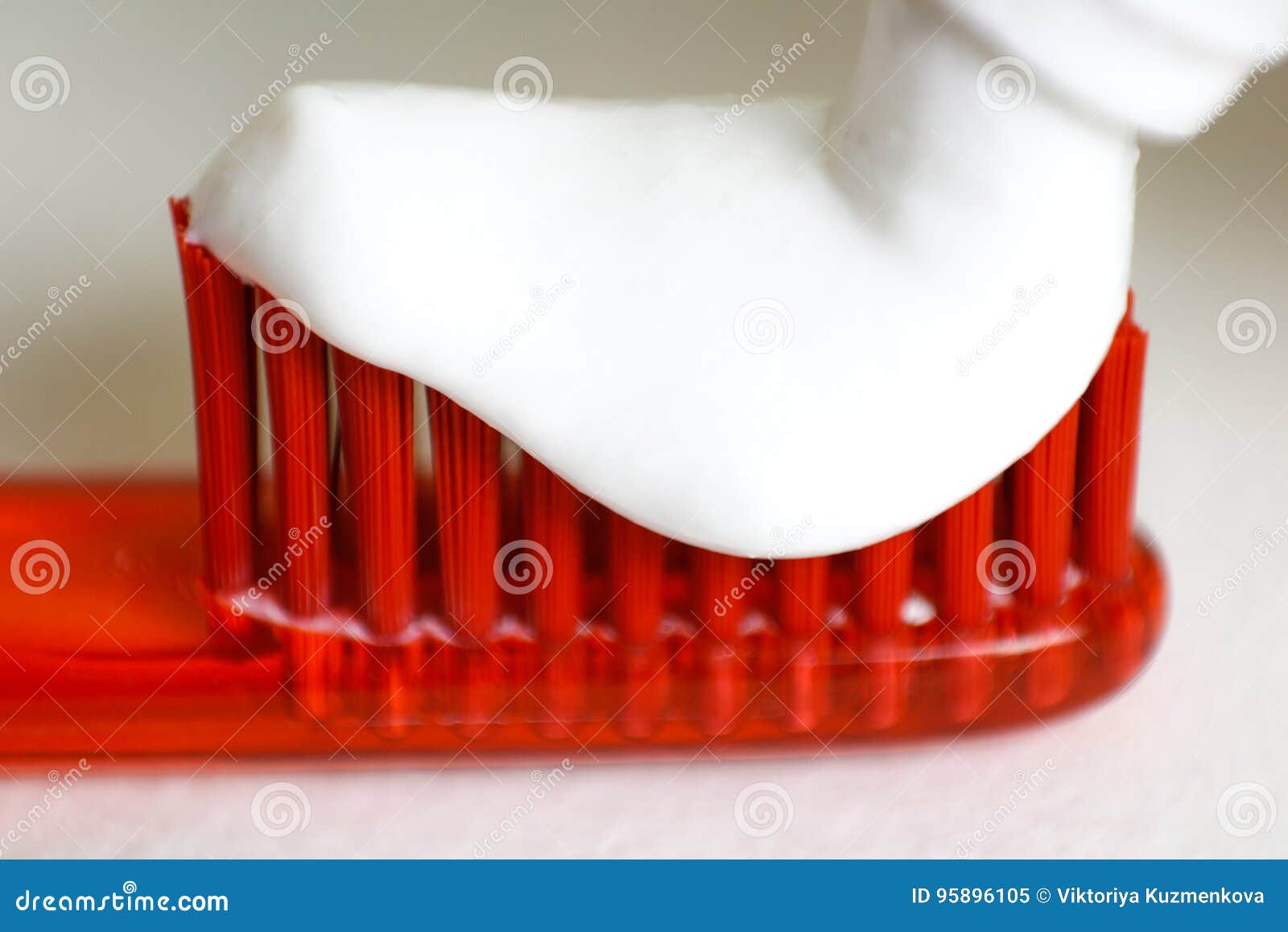 White Toothpaste on an Orange Toothbrush. Macro. Closeup. Isolated on a ...