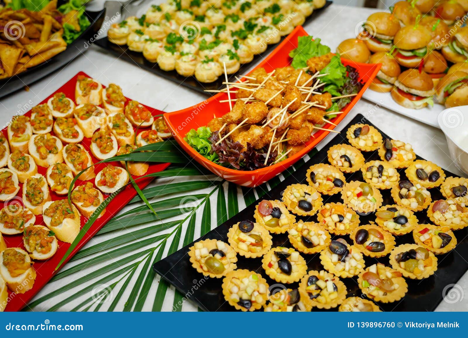 Evening Buffet Table with Treats. Fruit Tartlets, Mini Burgers, Chicken ...