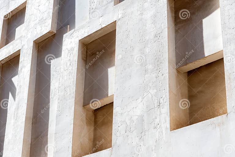 White Wall with Recessed Windows Creates an Abstract Pattern of Light ...