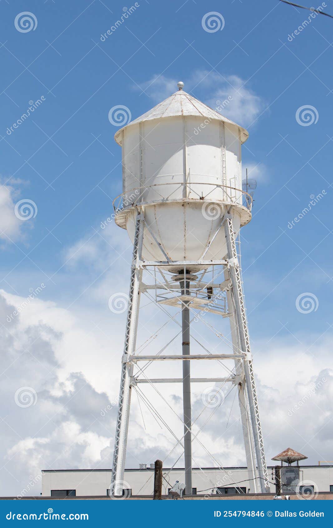 White Water Tower on Top of a Building Against a Cloudy Sky Stock Photo ...