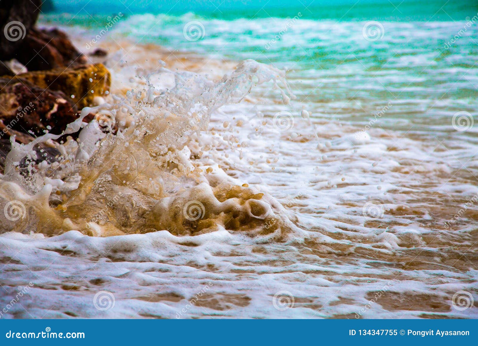 The White Wave Bumps the Brown Rocks at the Blue Sea on Brown Sand ...