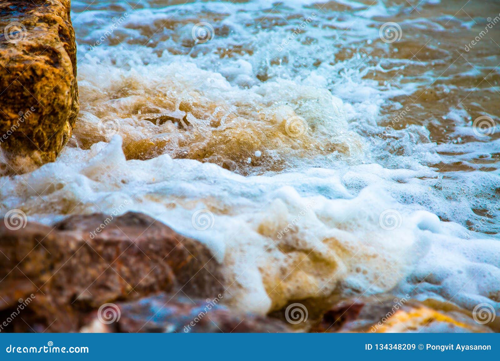 The White Wave Bumps the Brown Rocks at the Blue Sea on Brown Sand ...