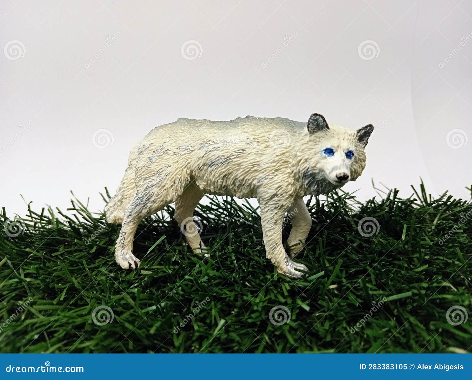 A White Wolf Toy Figure on Green Grass Stock Image - Image of white ...