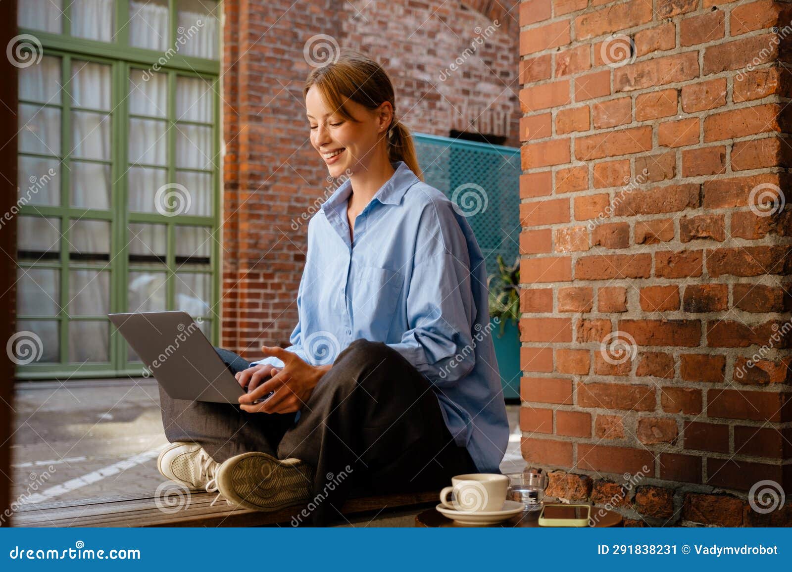 White Woman Smiling and Using Laptop while Resting in Cafe Outdoors ...