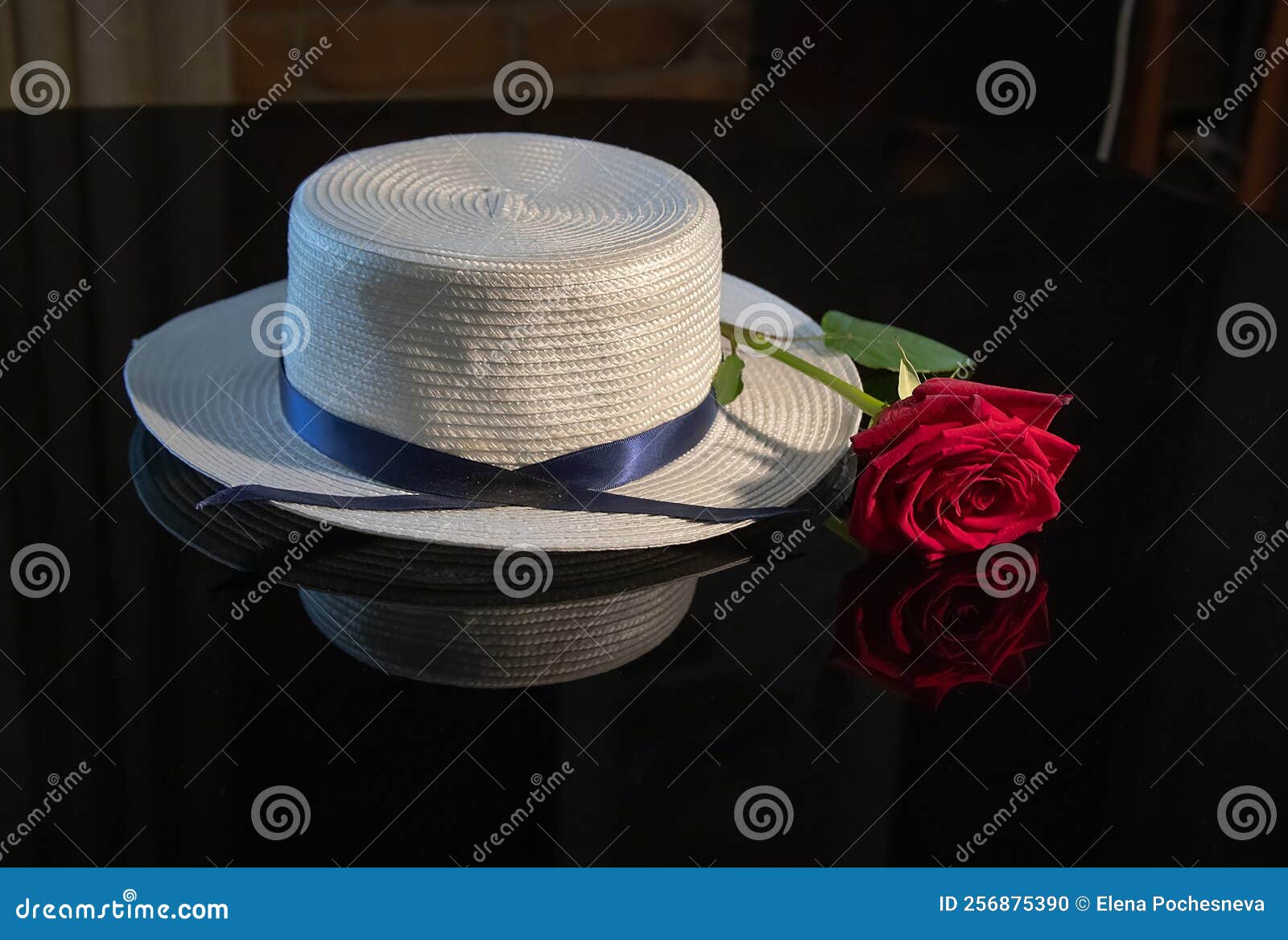 White Woven Straw Hat with a Blue Ribbon and a Red Rose on a Black ...