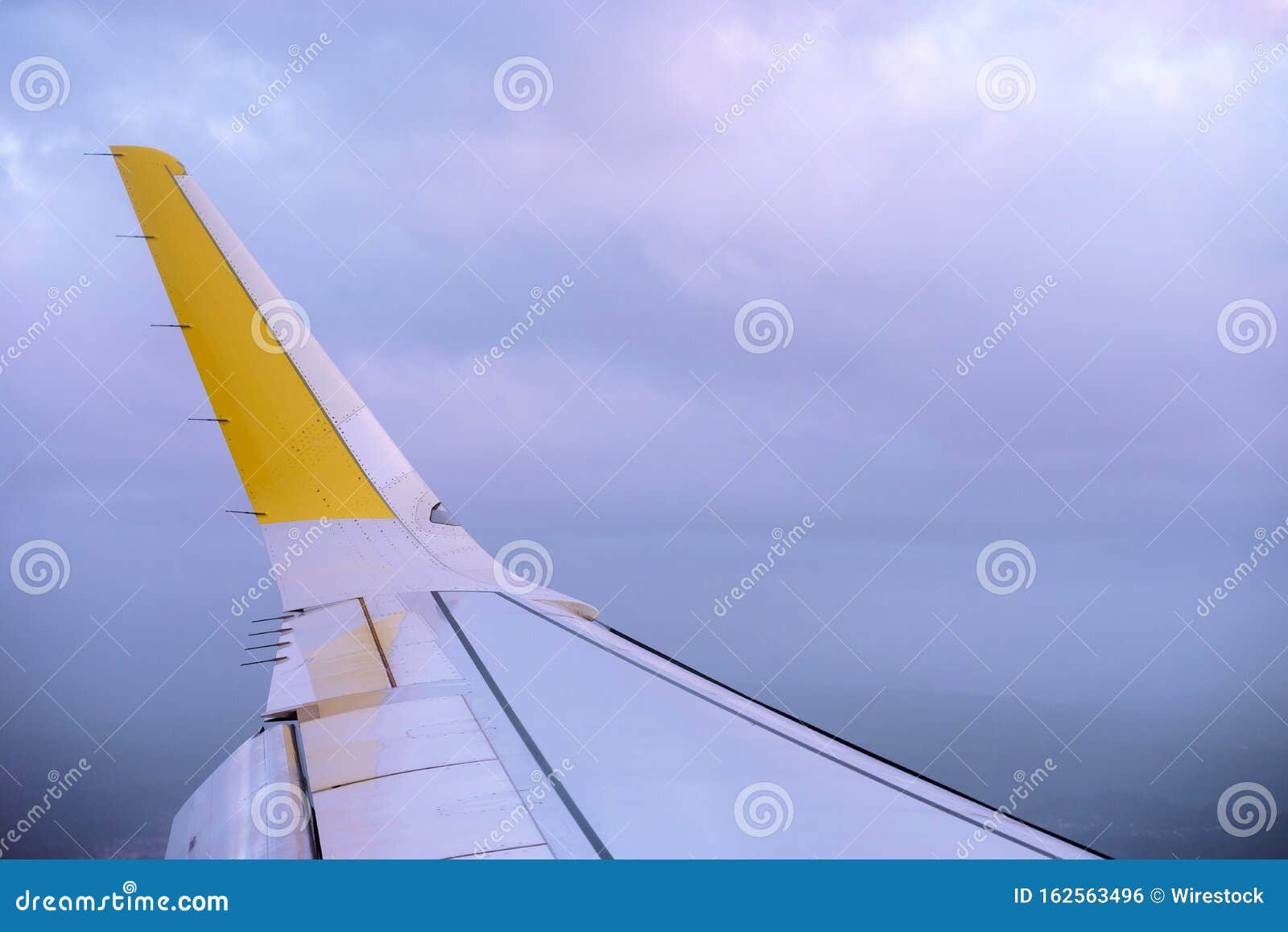 White and Yellow Wing of a Plane with the Beautiful Clouds in the ...