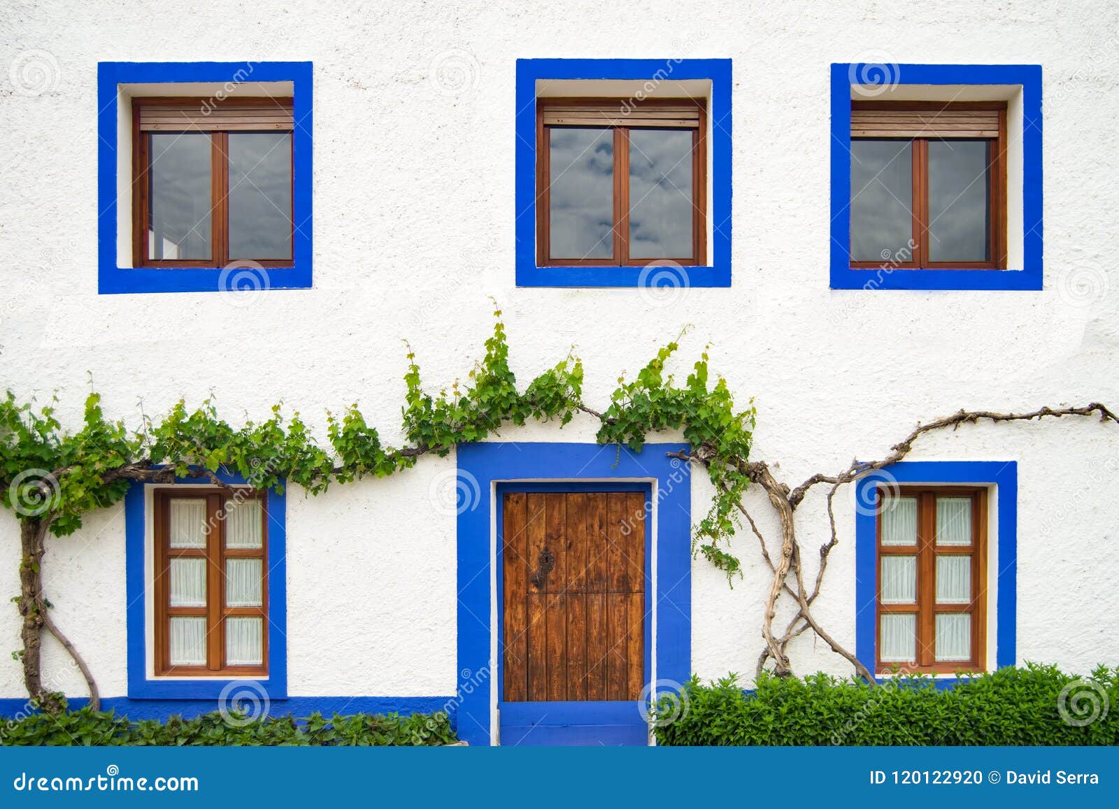 Whitewashed House Facade with Blue Windows Stock Photo - Image of ...