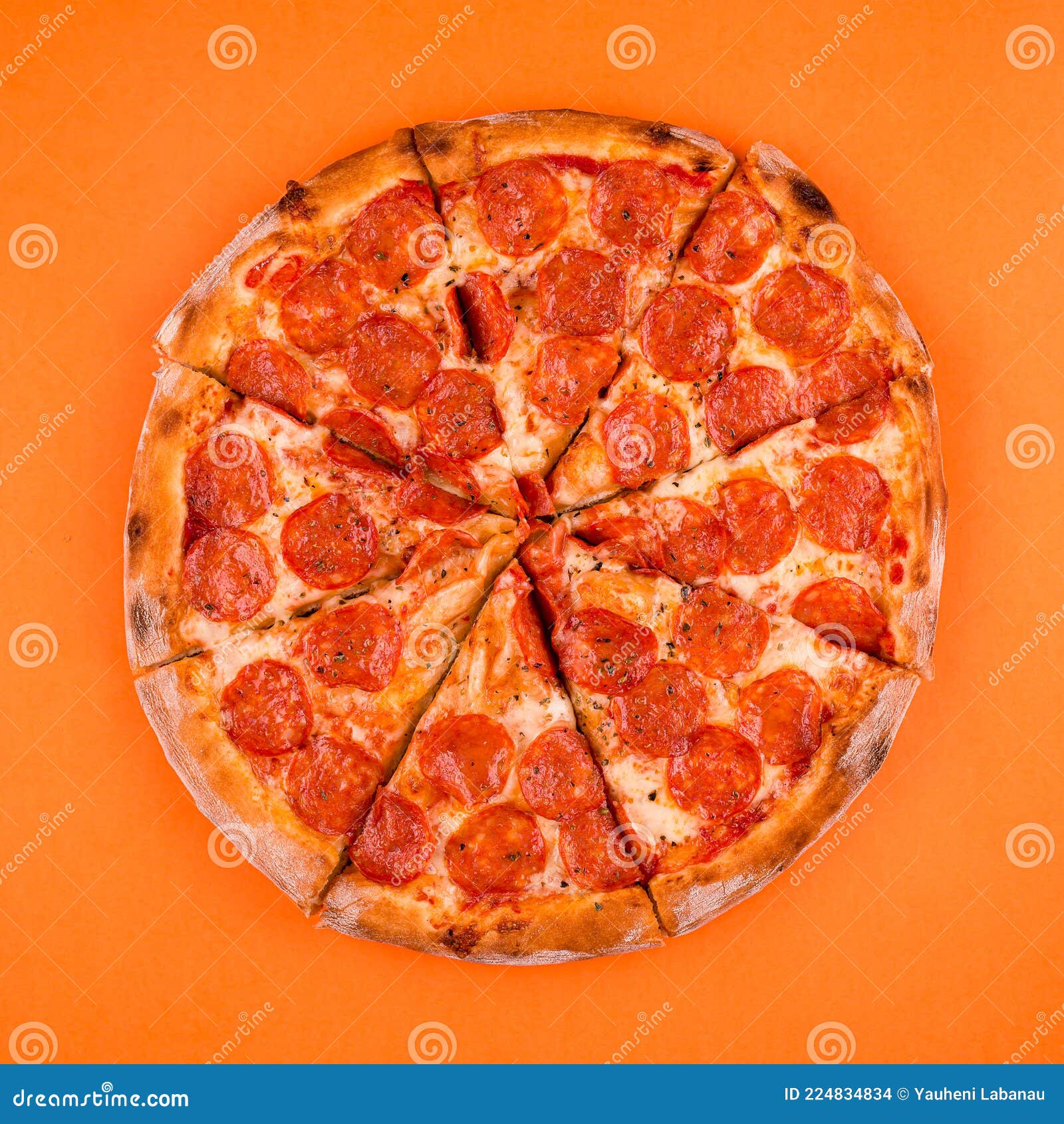 Whole, Cooked and Sliced Peperoni Pizza on a Bright Orange Background ...