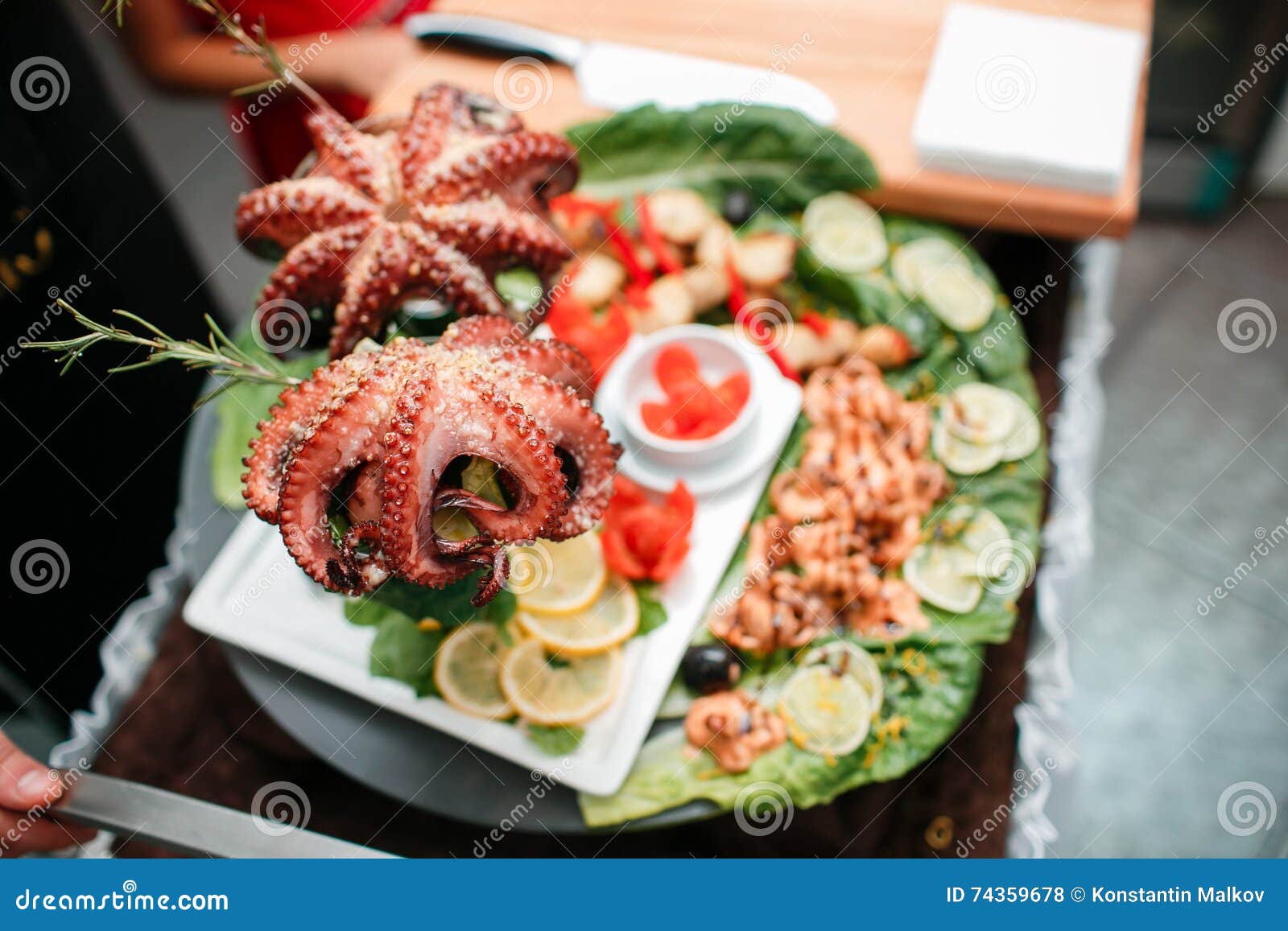 Whole Fresh Raw Octopus on Cutting Board with Lemon Rustic Wooden Table ...