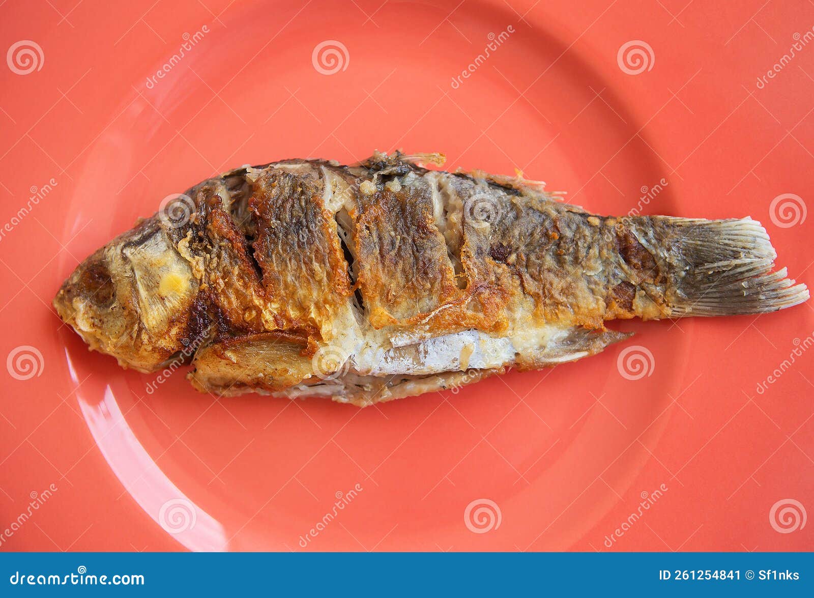A Whole Fried Carp with a Fried Crust, Served on a Bright Red Plate ...