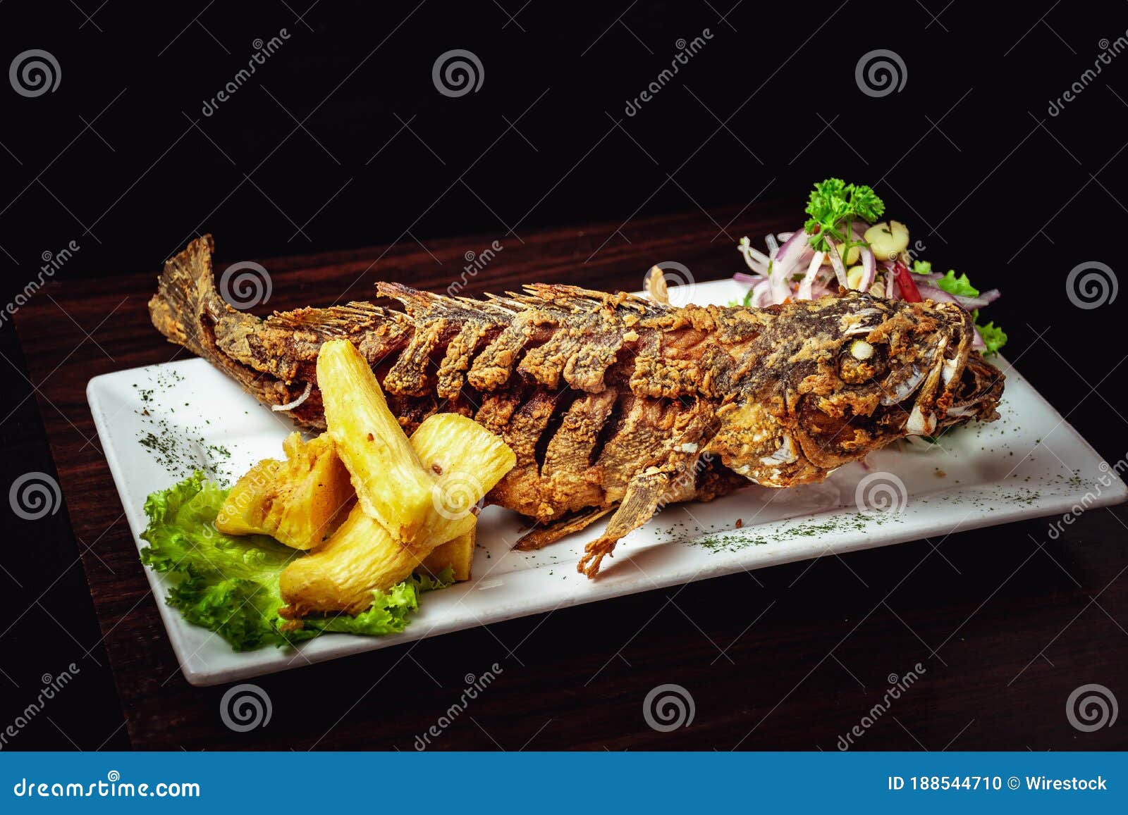 Whole Fried Fish Served with Yucca and Vegetable Salad Stock Photo ...