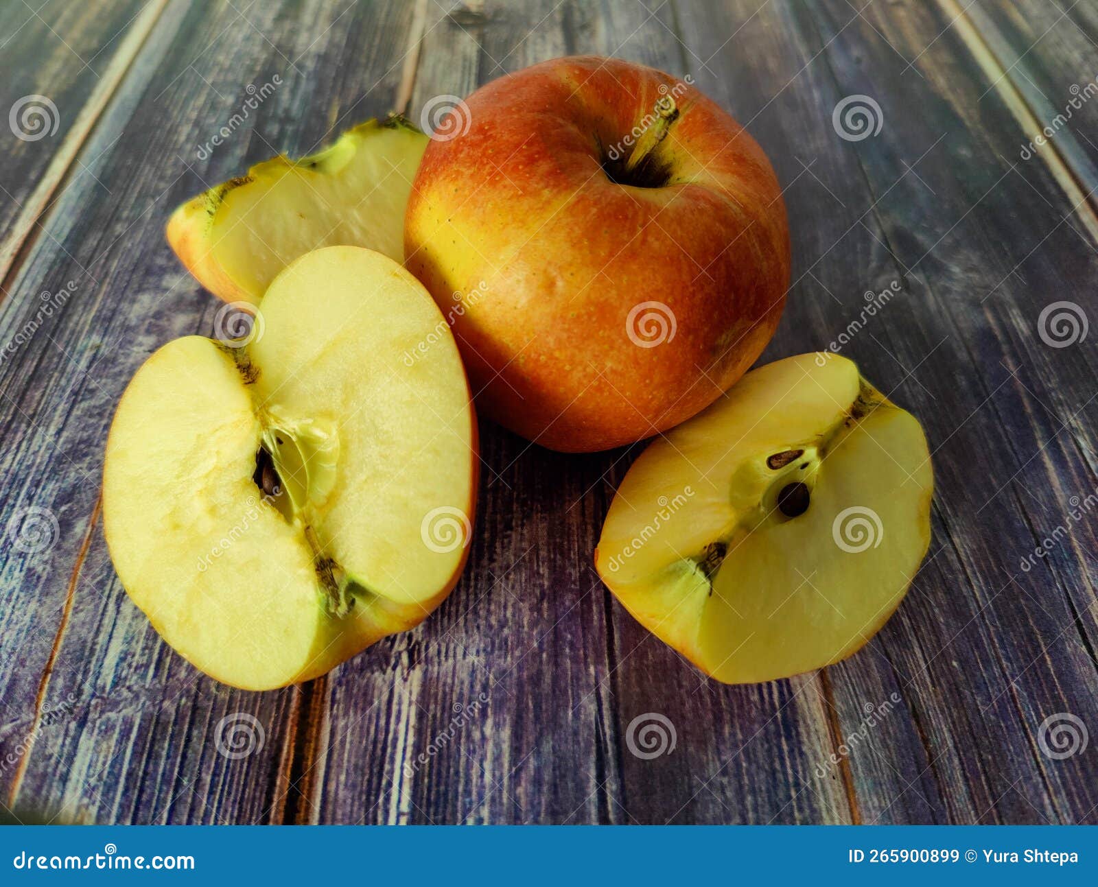 Whole Red Apple, Half and Two Quarter on a Wooden Table. Close-up Stock ...