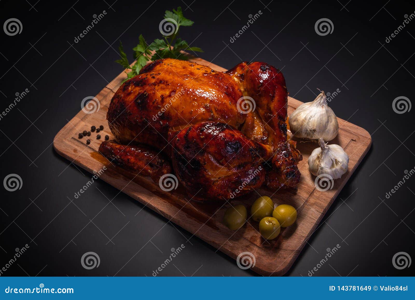 Whole Roasted Chicken on Cutting Board with Vegetables Over Black ...
