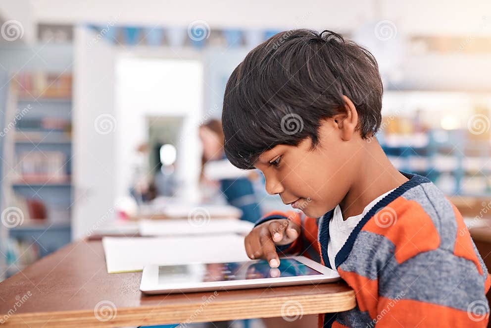 Why Use Books. a Focussed Young Elementary School Kid Browsing on a ...