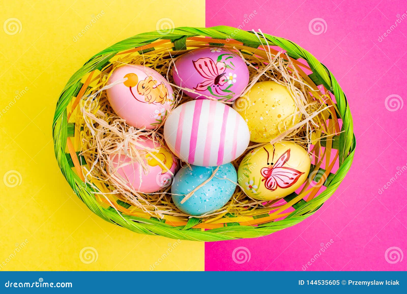 Wicker Basket with Easter Eggs Hand Painted on Color Tabletop ...