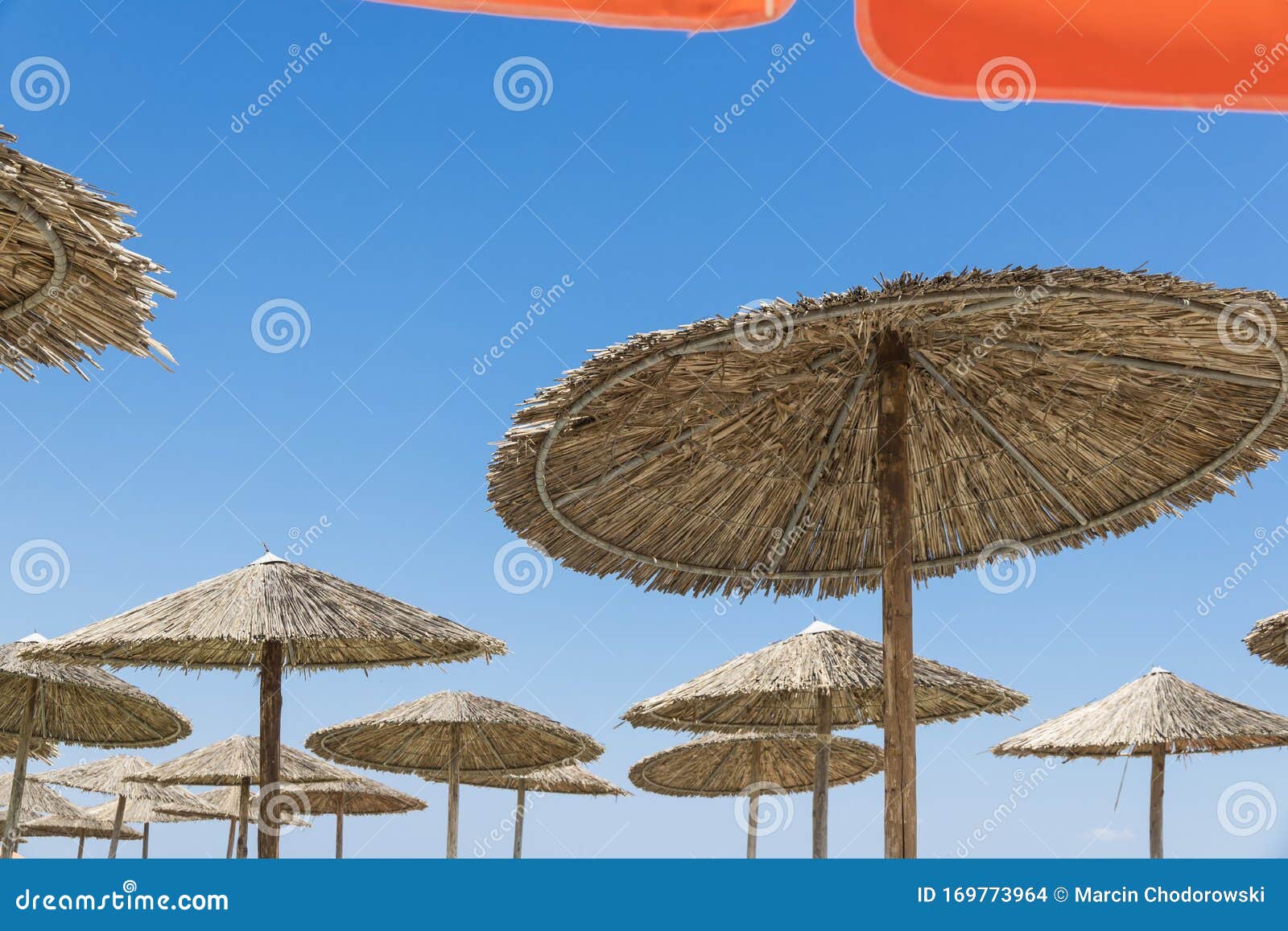 Wicker and Textile Orange Umbrellas on the Beach. Stock Photo - Image ...
