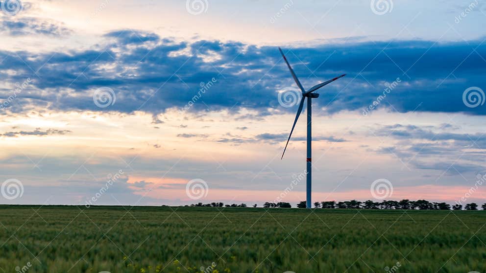 Wind Generator in Grass Field at Sunset Stock Photo - Image of clean ...