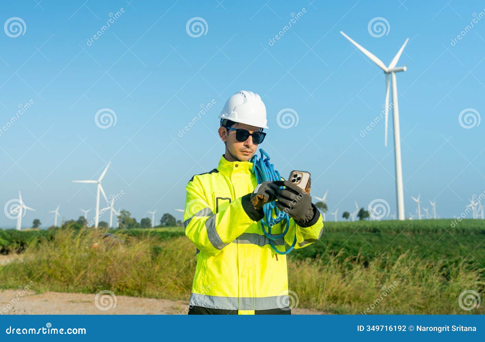 Wind Turbine or Windmill Engineer Worker Hold and Look To Mobile Phone ...