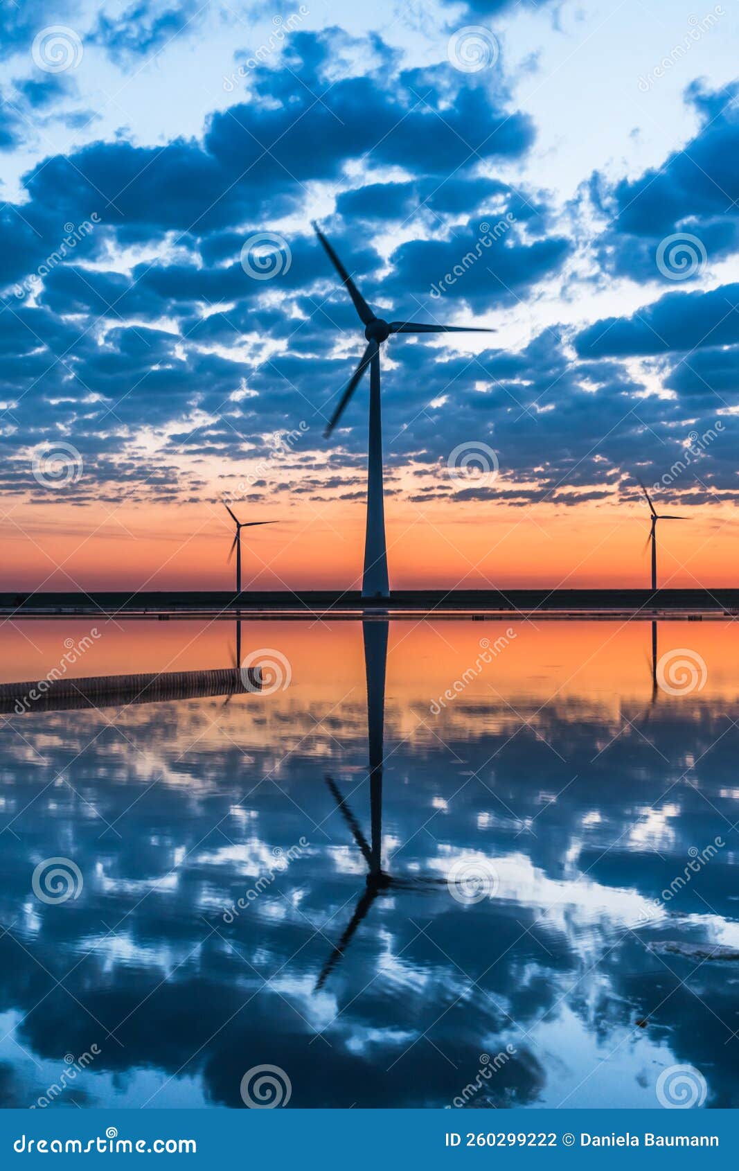 Wind Turbines in the Light of the Sunset with a Beautiful Reflection in the Water Stock Photo ...