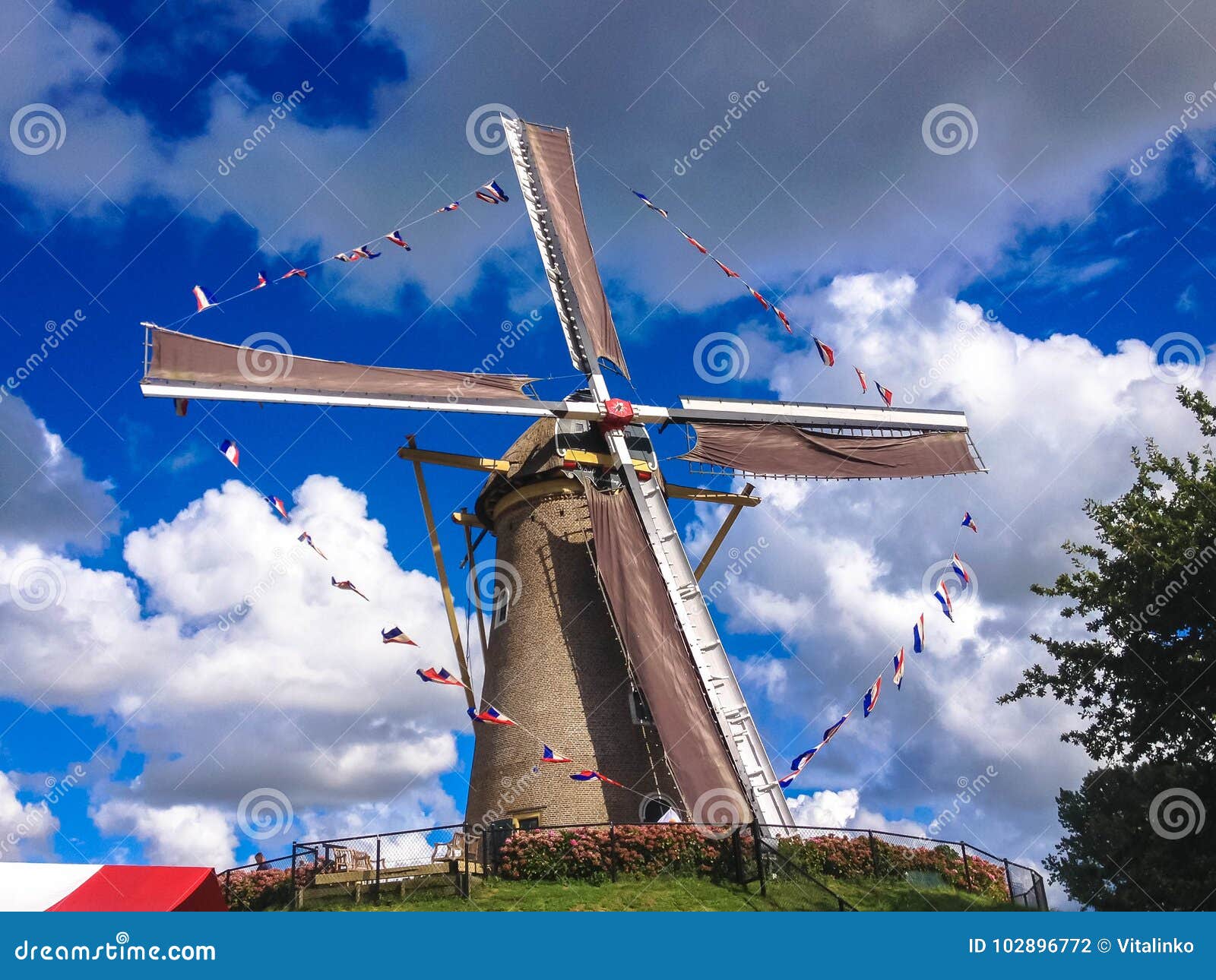 Windmill with Dutch Flags between Its Blades. Stock Photo - Image of ...