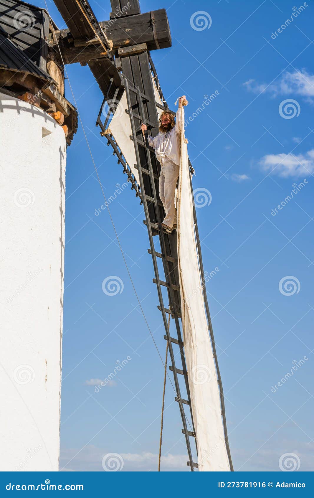 Windmill with Man Climbing on the Blades To Install the Tarp To Make it ...
