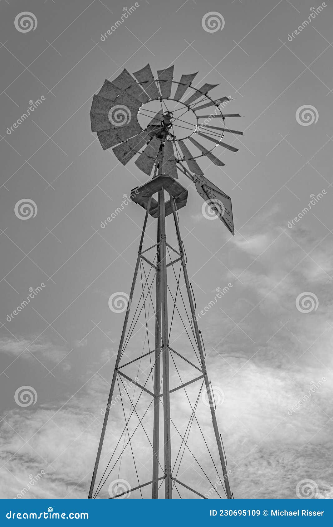 Windmill Pump in Grayscale Against Light Sky and White Clouds Stock ...