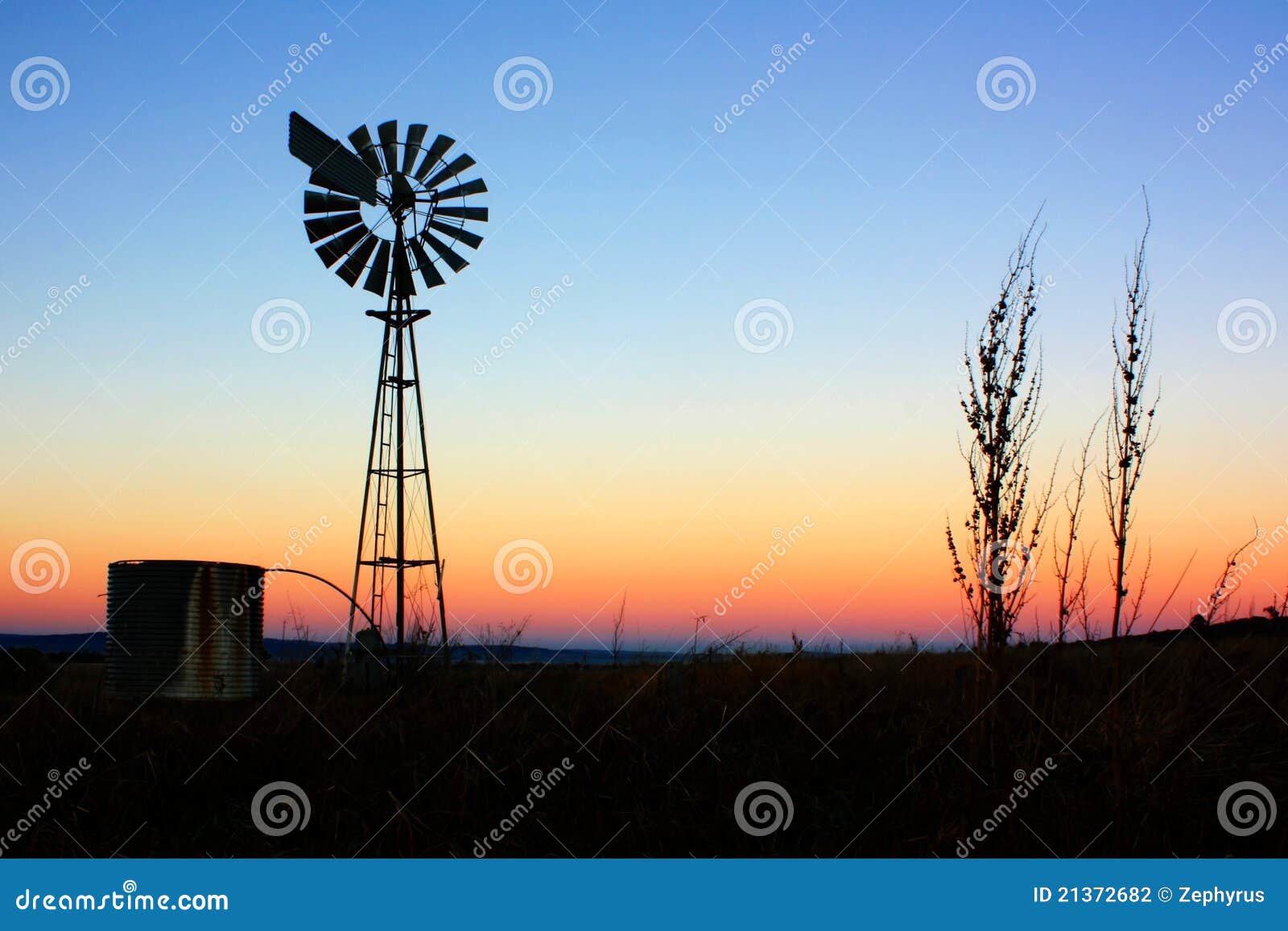 Windmill Silhouette at Sunrise. Stock Photo - Image of sunrise, hues ...