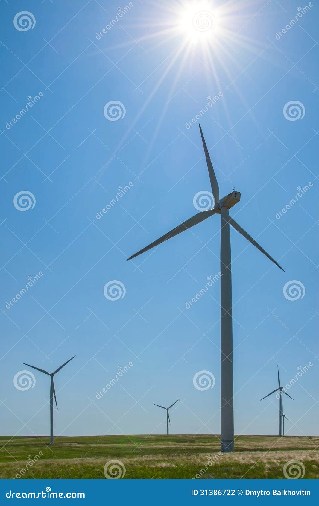 Windmills on Field, Sun in Blue Sky Stock Photo - Image of cable ...