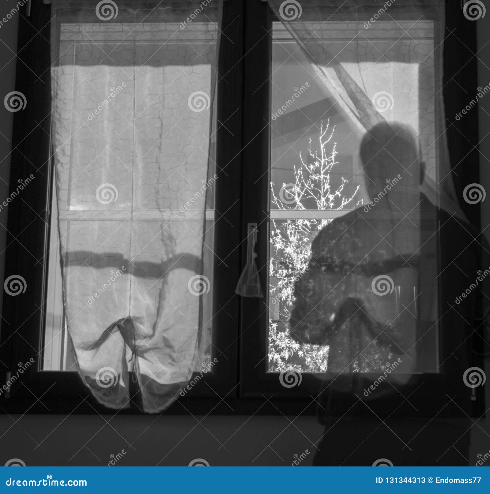 Window with Curtain and Artificial Light Outside and Man Shadow in ...