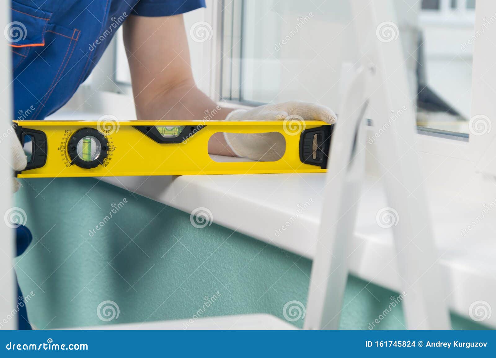 A Window Installation Worker Checks the Level of the Window Sill with a ...