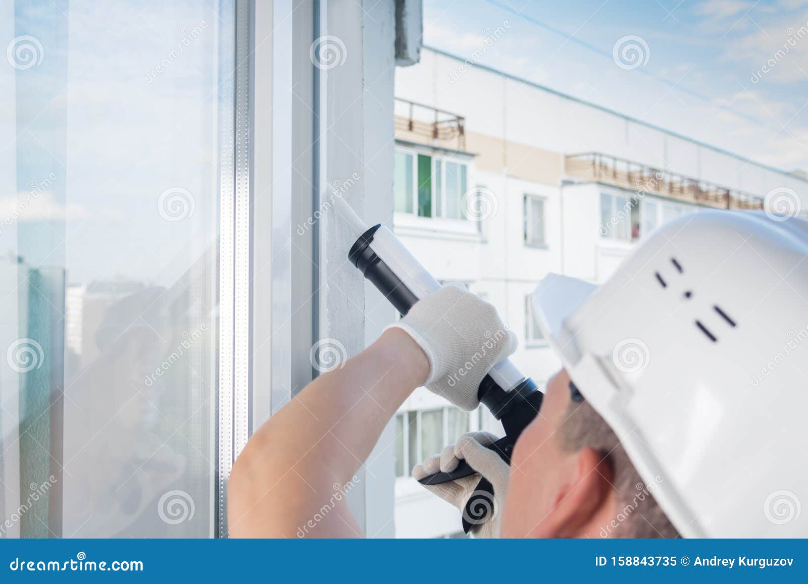 A Window Installation Worker Seals a Plastic Window Frame with a ...