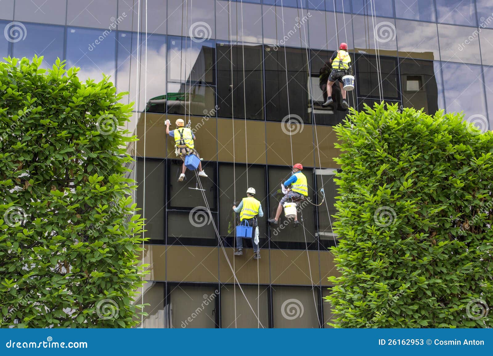 Four Window Washers Work At A Height On A High-rise Building With A ...