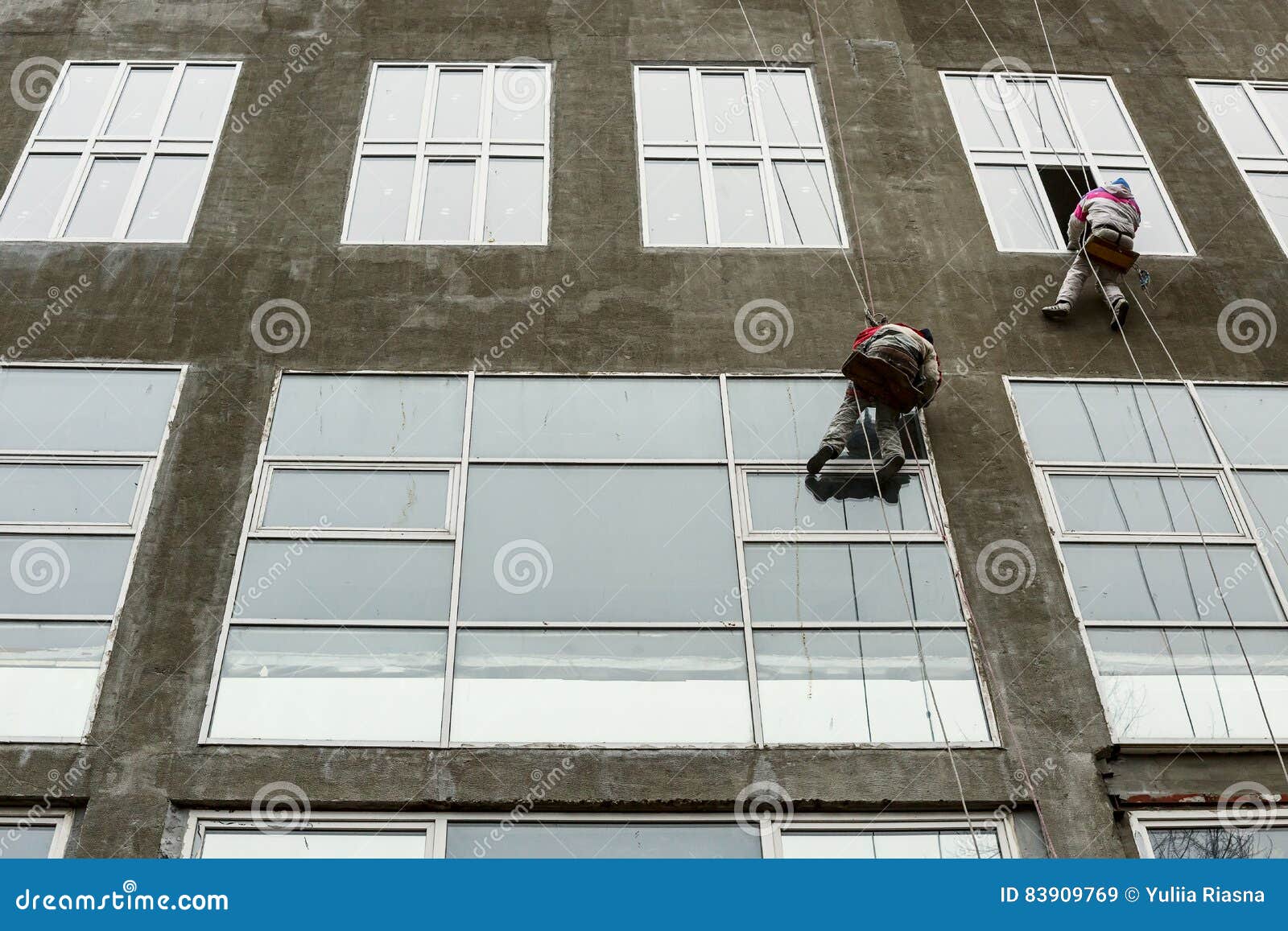 Window Washers on Top. Two Workers Hung Ropes Wash Windows on High-rise ...