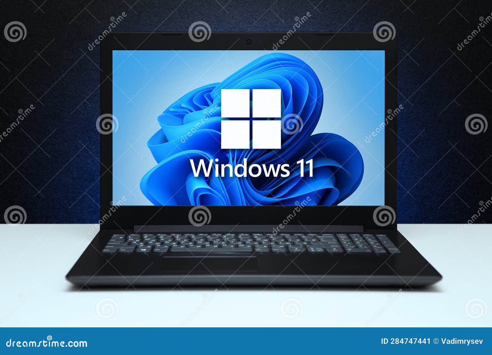 Windows 11 Logo on the Screen Laptop Computer on Black Textured Wall ...