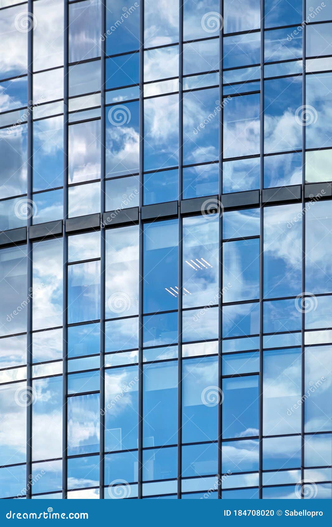 Windows of a Skyscraper with Reflection of Blue Sky and White Clouds. a ...