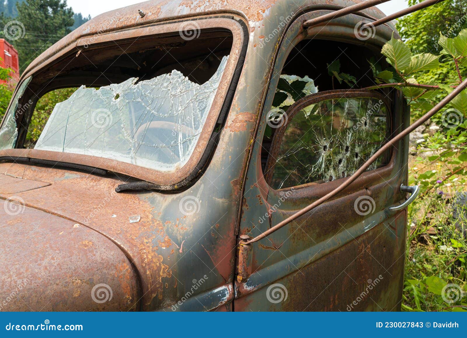 Windshield and Driver Side Window with Bullet Holes on a Rusty Antique ...