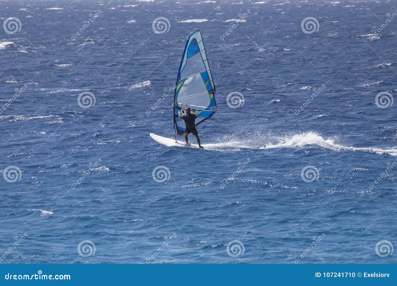 Windsurfer on a Board Under a Sail Against the Background of the Sea ...