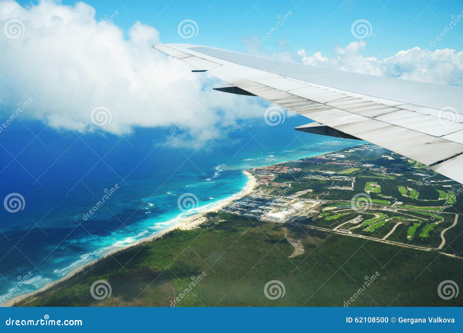 Wing of an Airplane Flying Above the Clouds Over Tropical Island Stock ...
