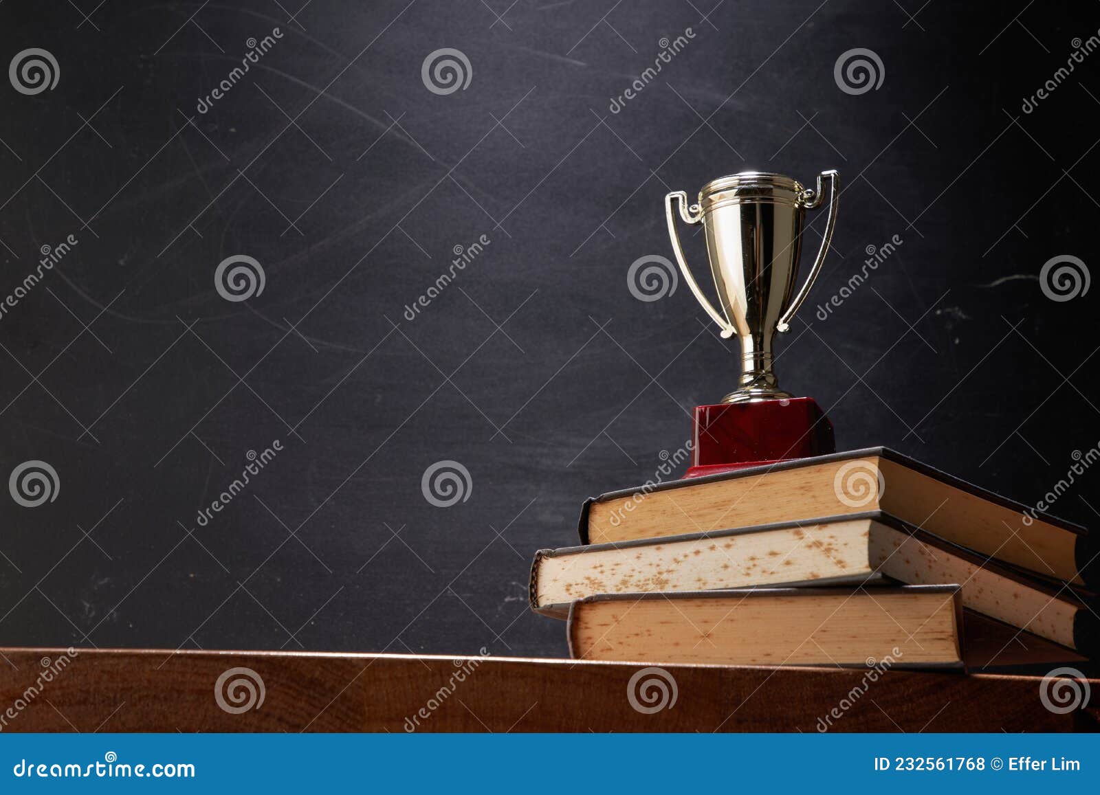 Wining Trophy on Stack of Book Against Blackboard Stock Photo - Image ...