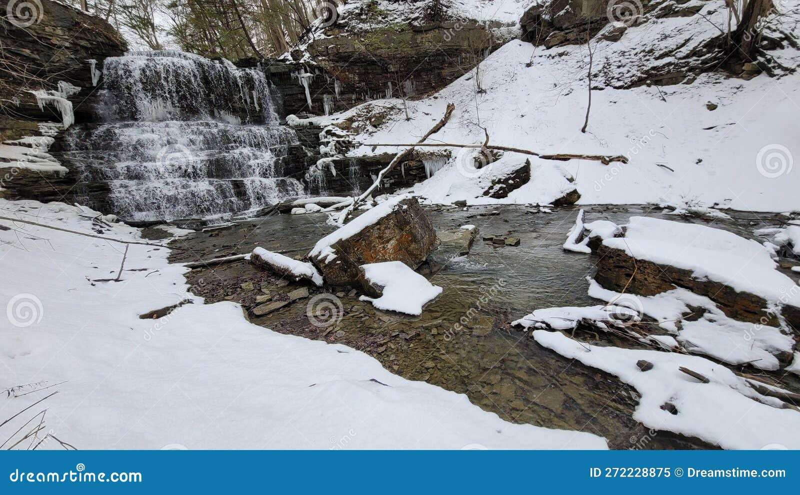 Winter Scene Featuring a Waterfall Cascading Down a Rocky Cliff Amid a ...
